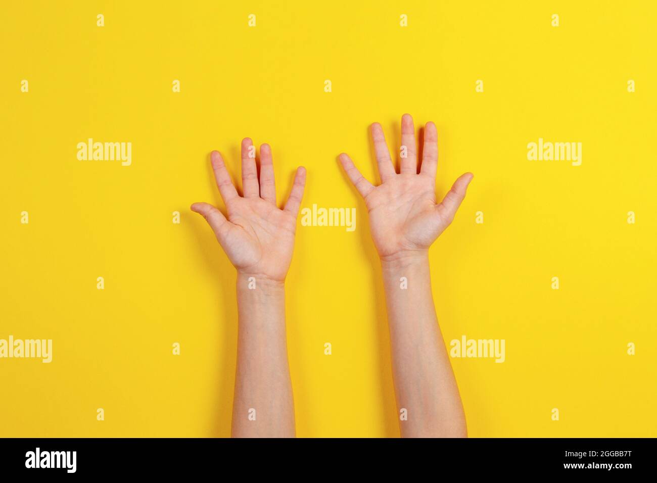Two kid arms on yellow background. Top view to empty opened palms up ... Two kid arms on yellow background. Top view to empty opened palms up ...