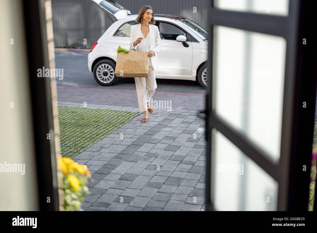 Woman going home with groceries Stock Photo - Alamy