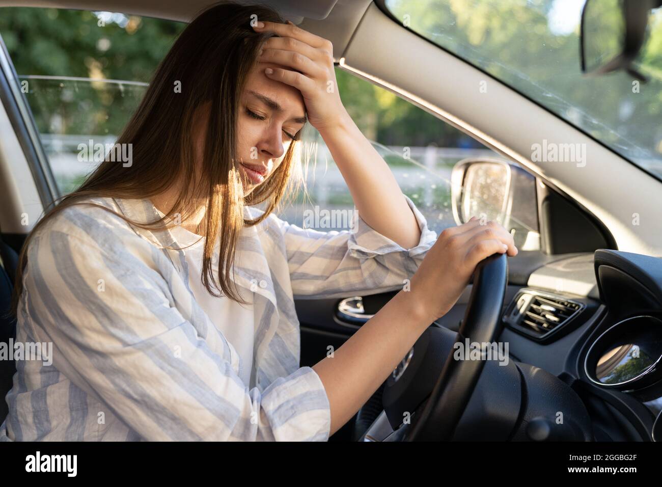 Tired young woman car driver suffer from headache or migraine pain ...