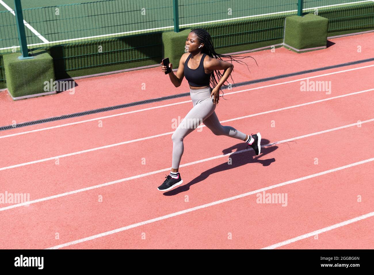 African woman athlete running on racetrack. Sportive black female ...