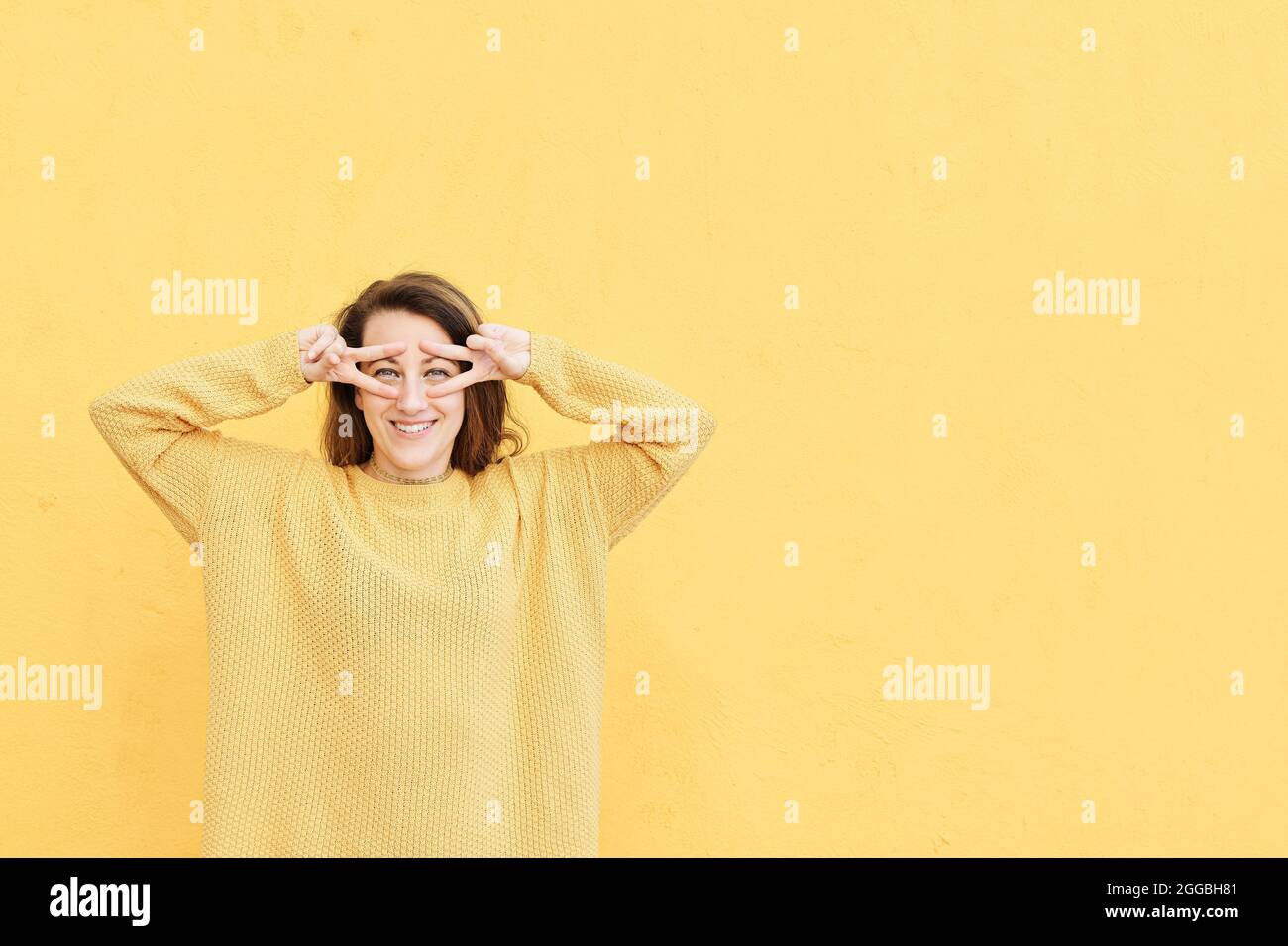 portrait of funny teenage girl making v-signs or peace sign, near her ...