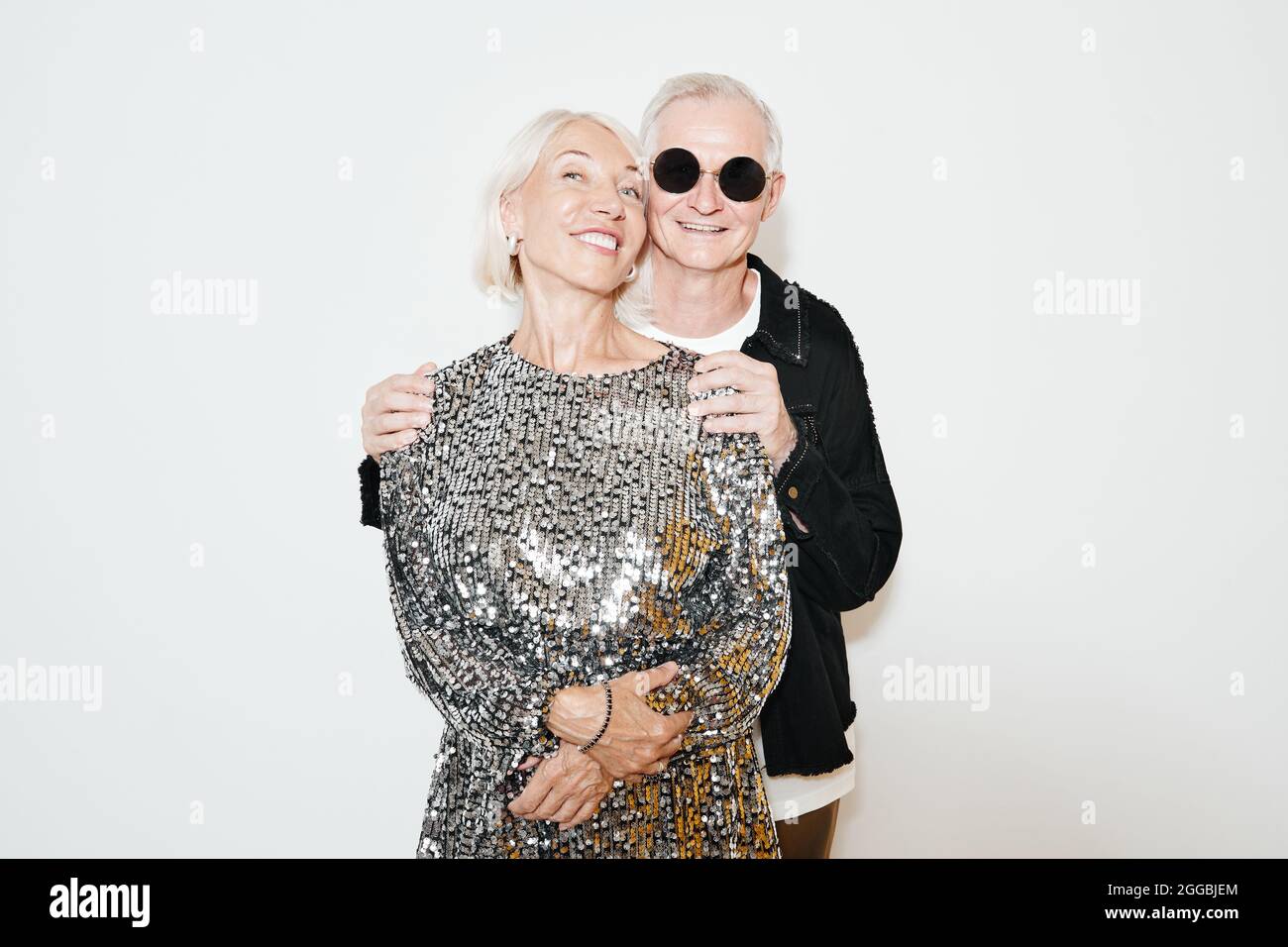 Waist up portrait of glamorous senior couple posing together against ...