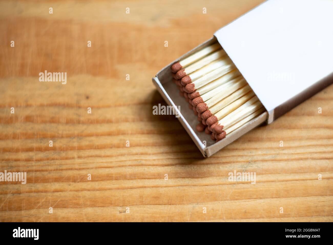 Wooden safety matchsticks stacked in cardboard matchbox on wooden ...