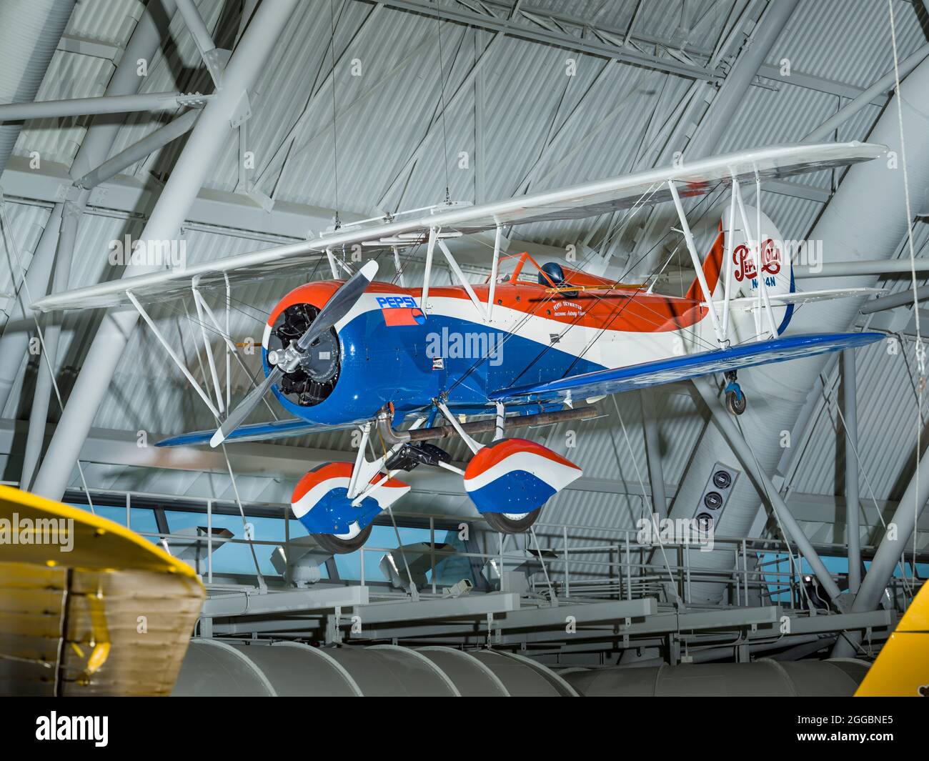Three-place, open-cockpit biplane with red, white and blue paint scheme ...
