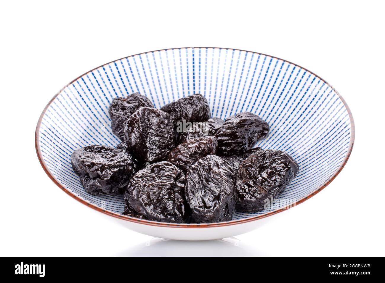 Organic tasty prunes on a white dish, close-up, on a white background ...