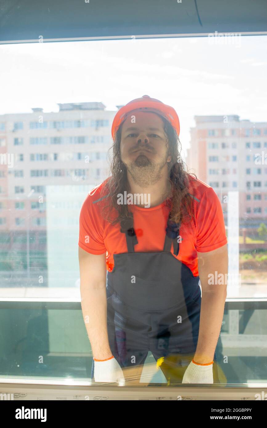a sad engineer in a helmet grimaces behind glass Stock Photo - Alamy