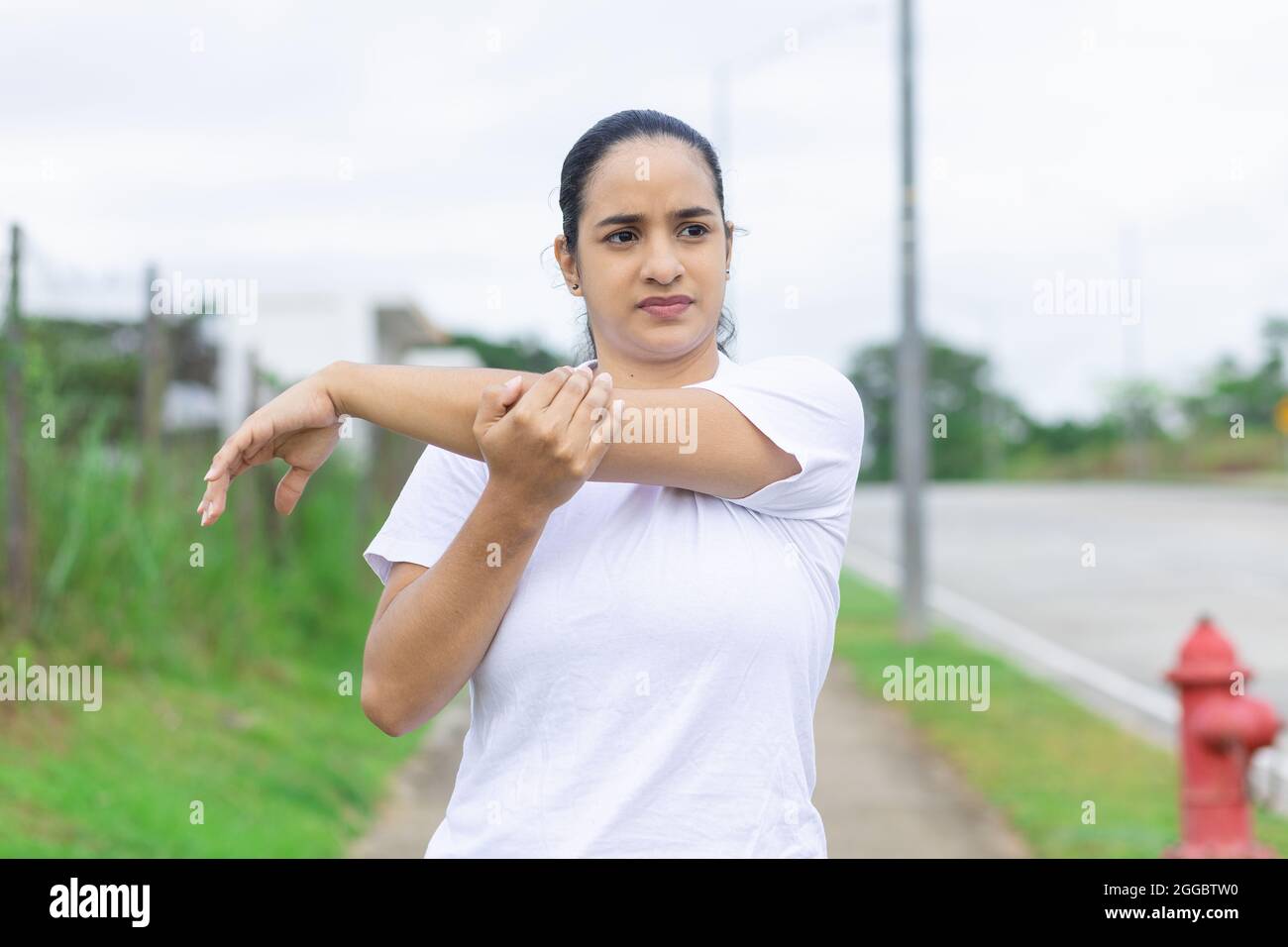 Closeup of a girl doing arm-stretching outdoors Stock Photo - Alamy