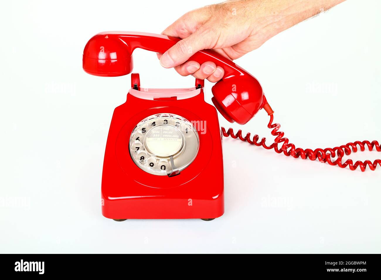 Mans hand holding a vintage red GPO telephone handset isolated on a ...