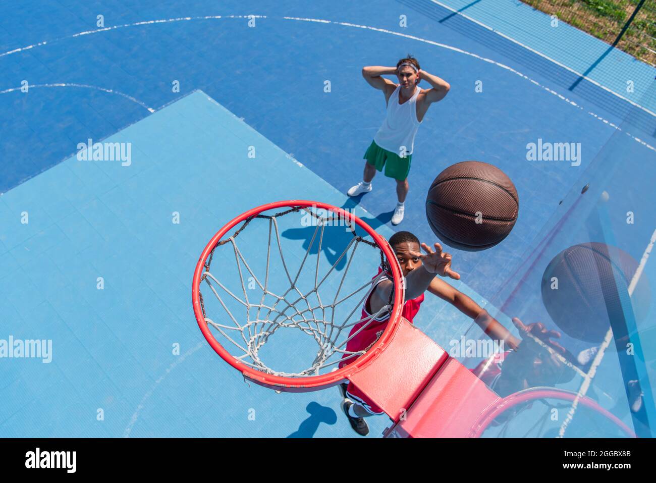 Top view of african american sportsman throwing ball in hoop on ...