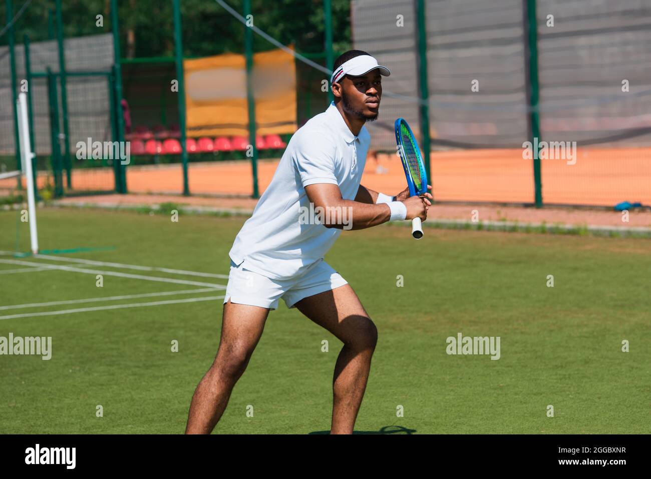 Athletic african american man playing tennis on court Stock Photo - Alamy
