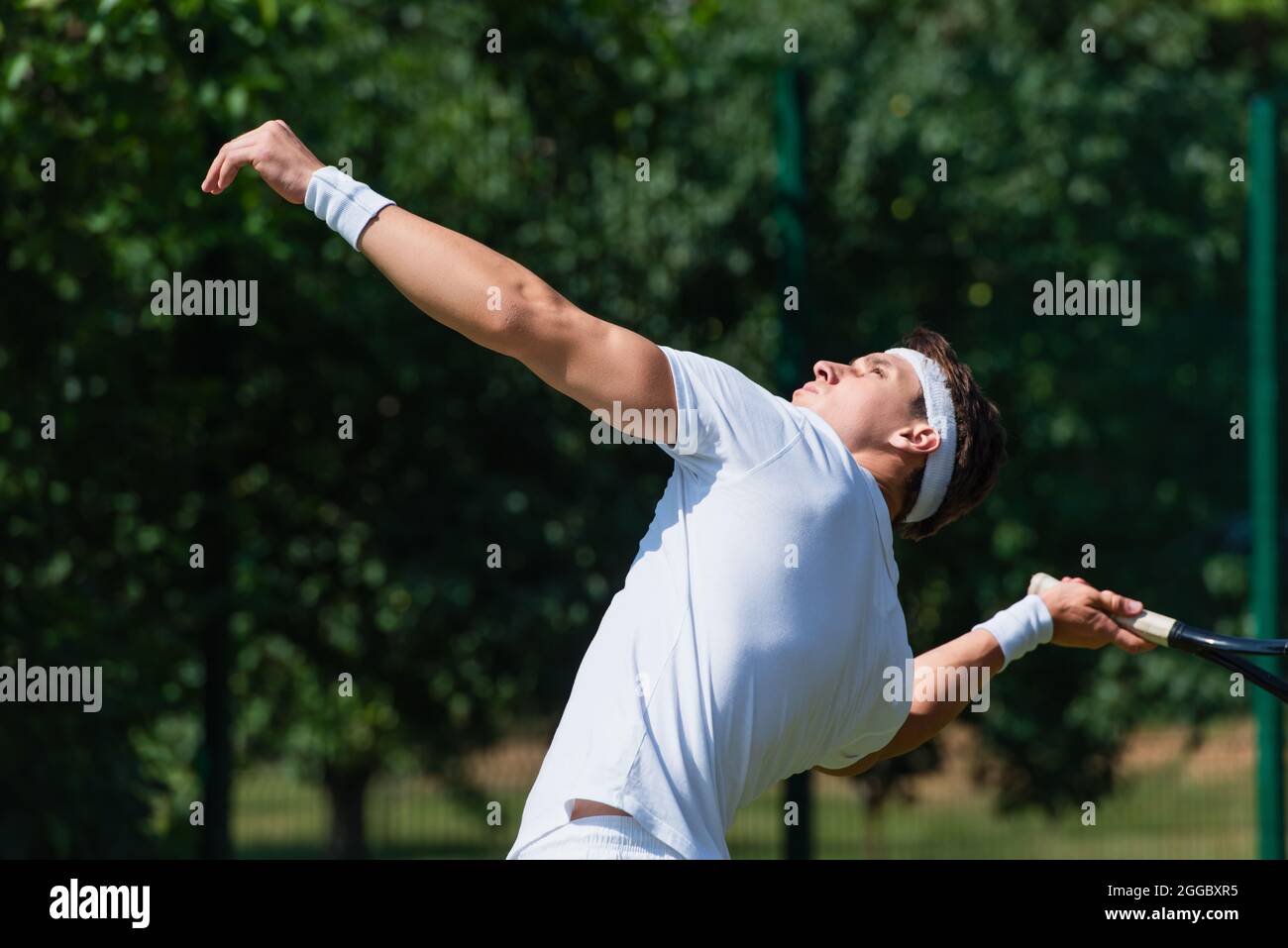 Side view of athletic sportsman playing tennis outdoors Stock Photo - Alamy