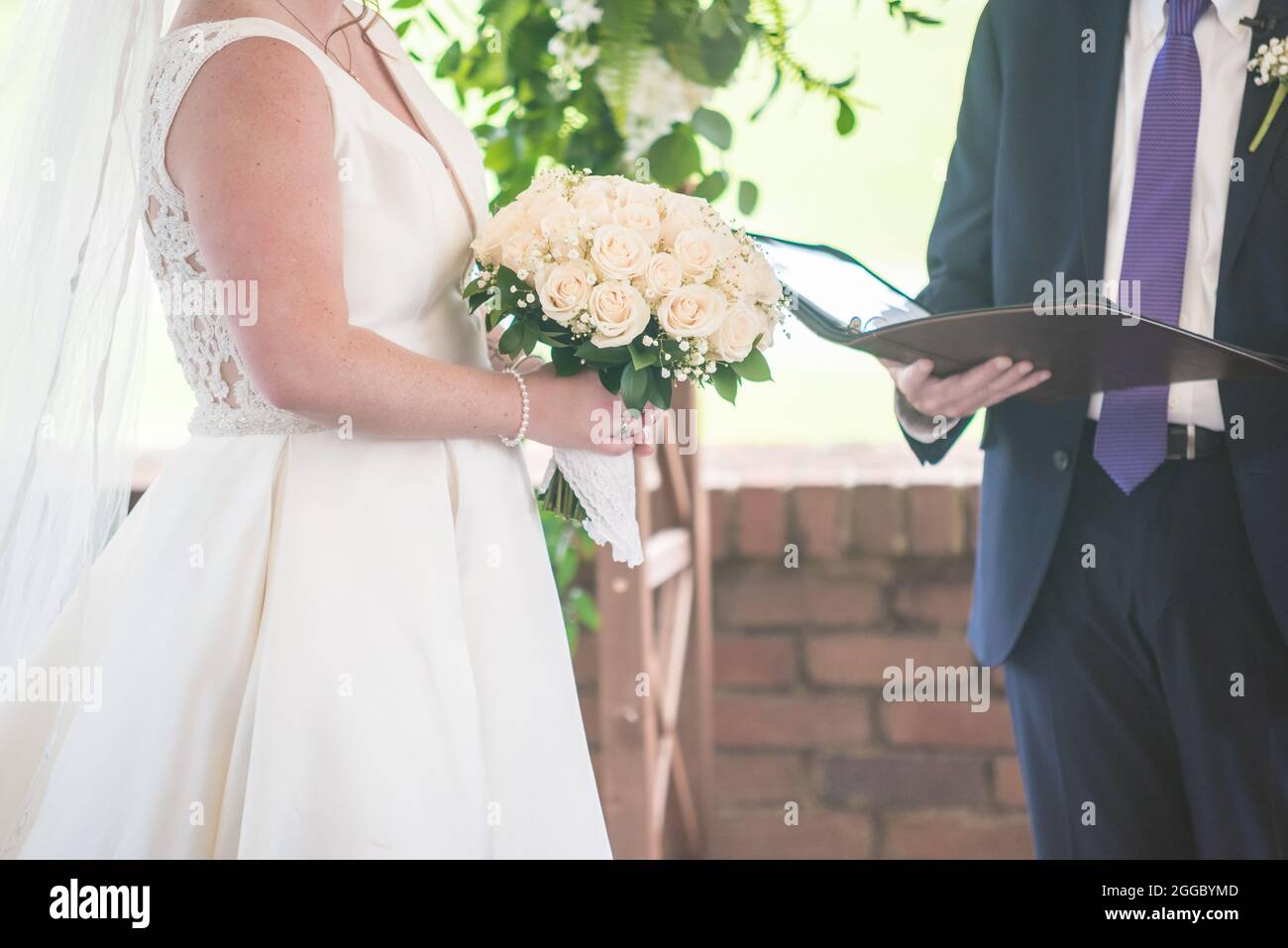 Bride's hands holding the flowers during exchanging vows ceremony Stock ...