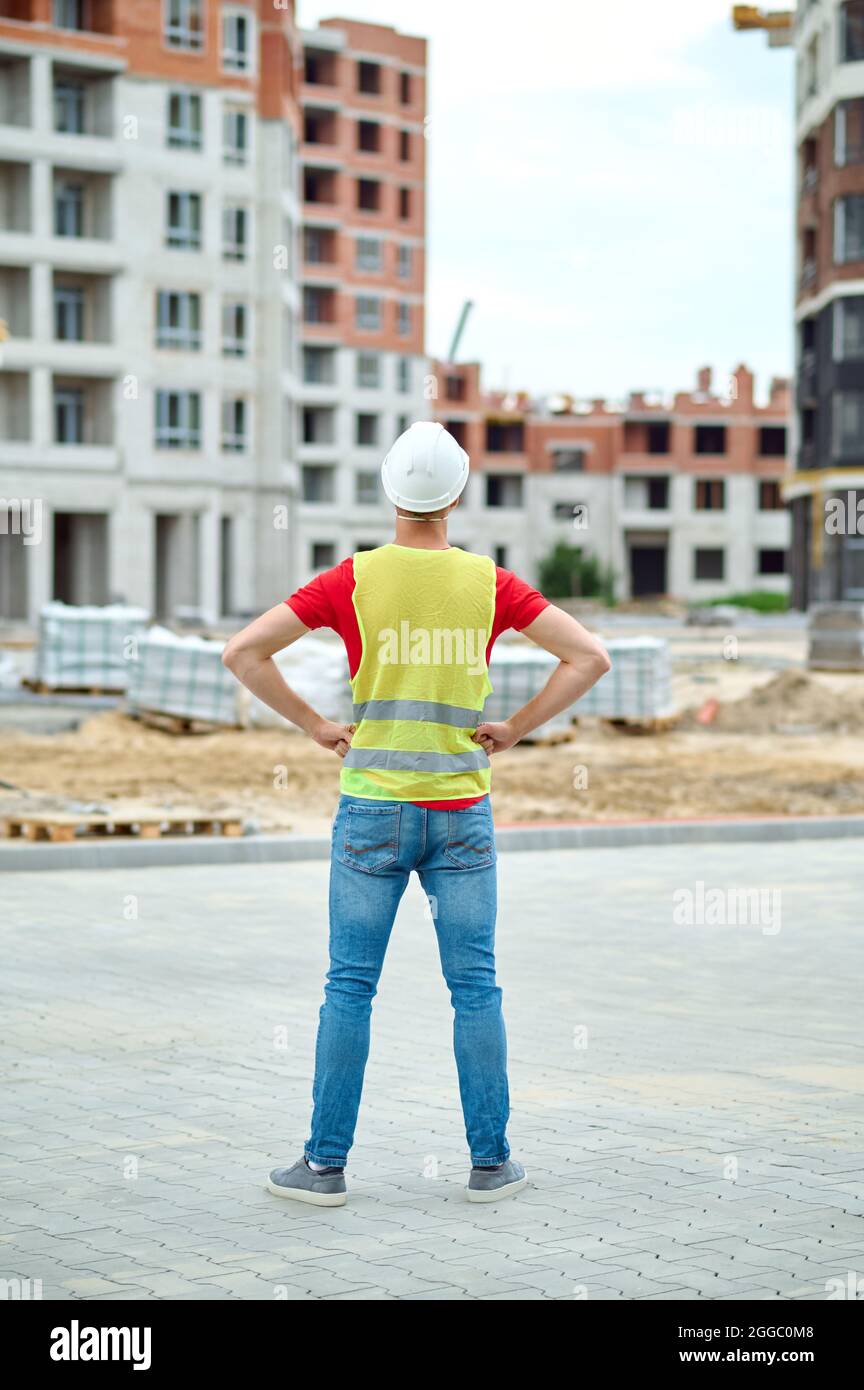 Experienced builder in a safety helmet examining a building area Stock ...