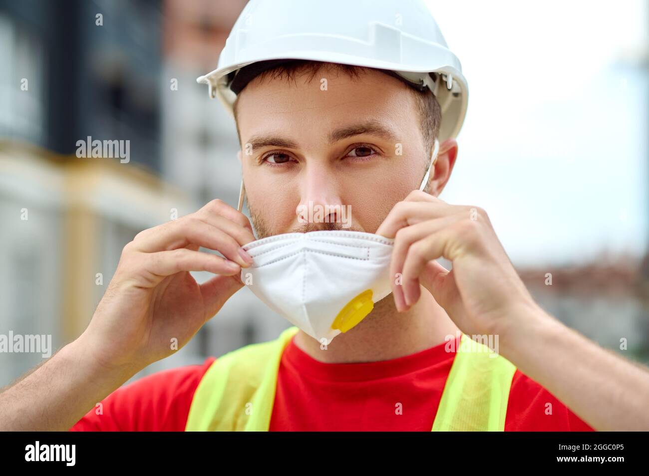 Skilled serene young worker getting ready for work Stock Photo - Alamy