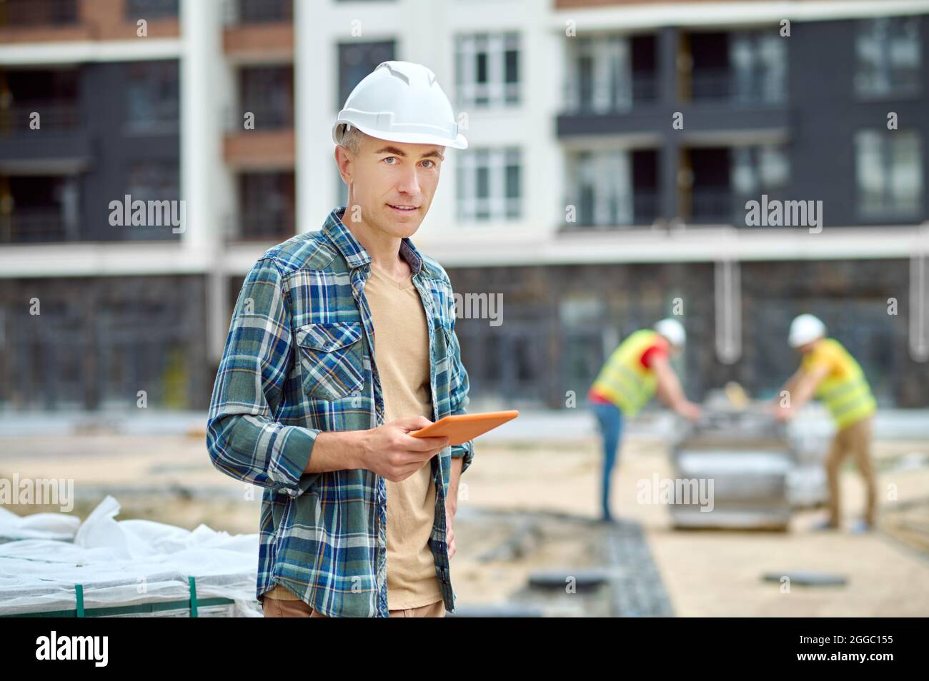 Calm engineer posing for the camera on the construction site Stock ...