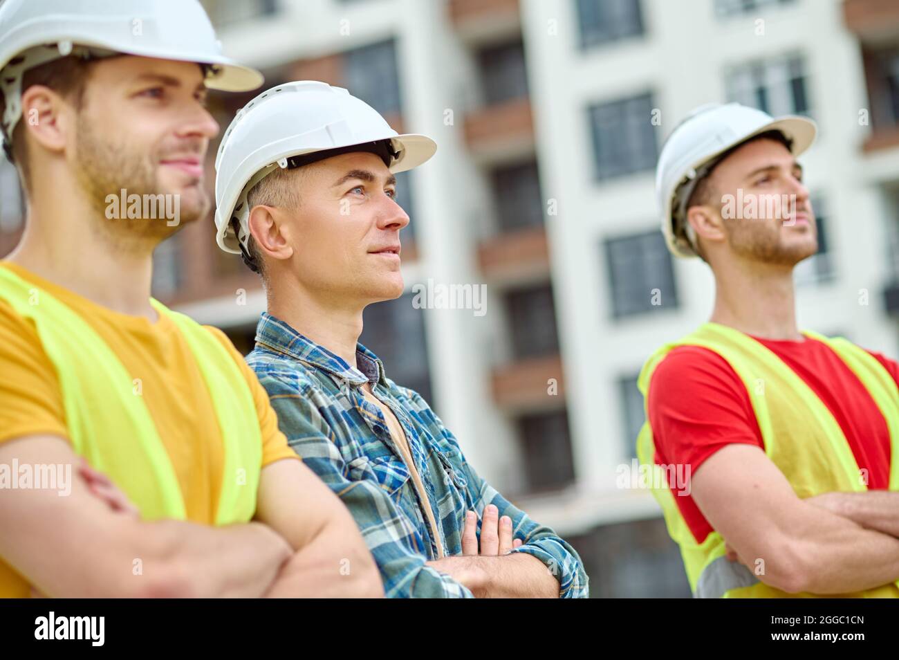 Three handsome focused construction workers staring at something Stock ...