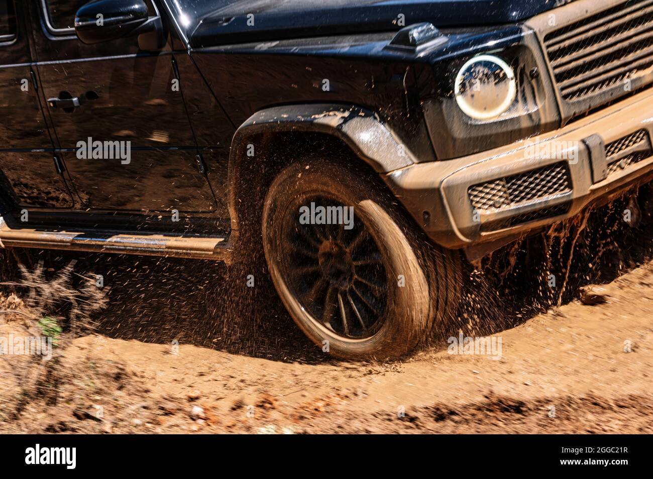 Close-up tire of a 4x4 vehicle in full action, Splashing mud and water ...