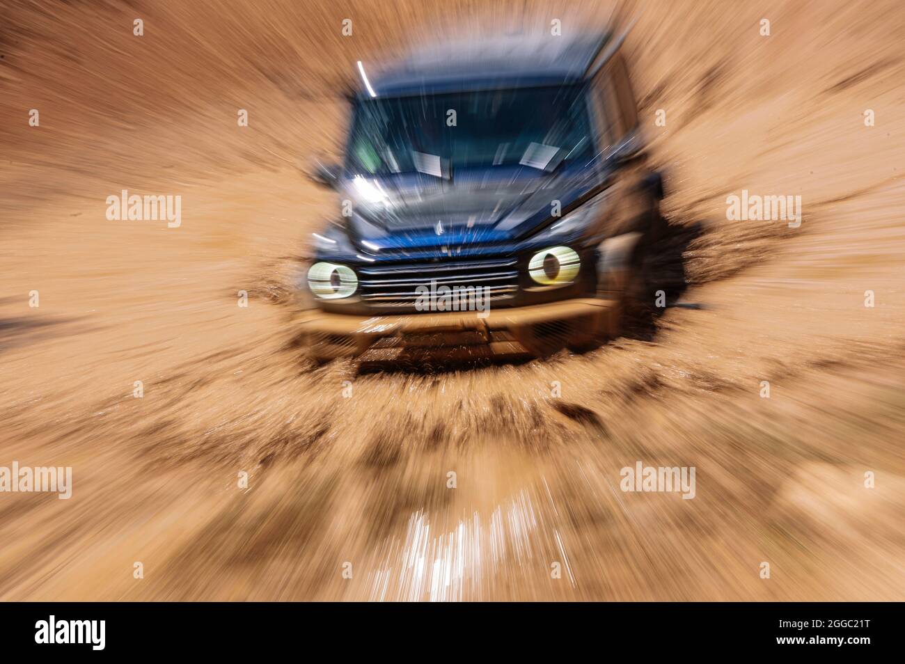 4x4 vehicle in full action going through a large puddle of water and ...