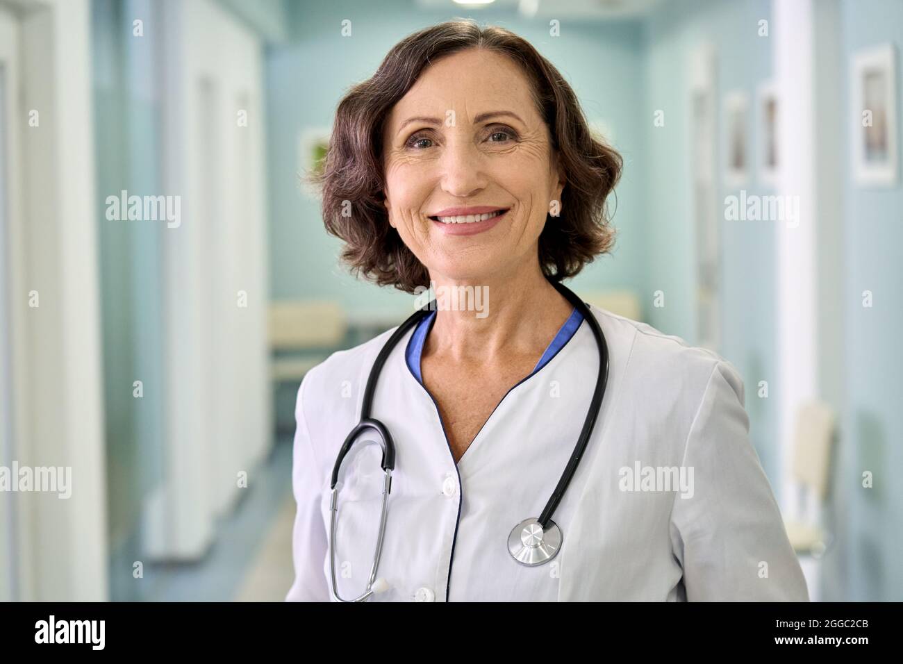 Smiling female happy doctor pediatrician standing in clinic hospital ...