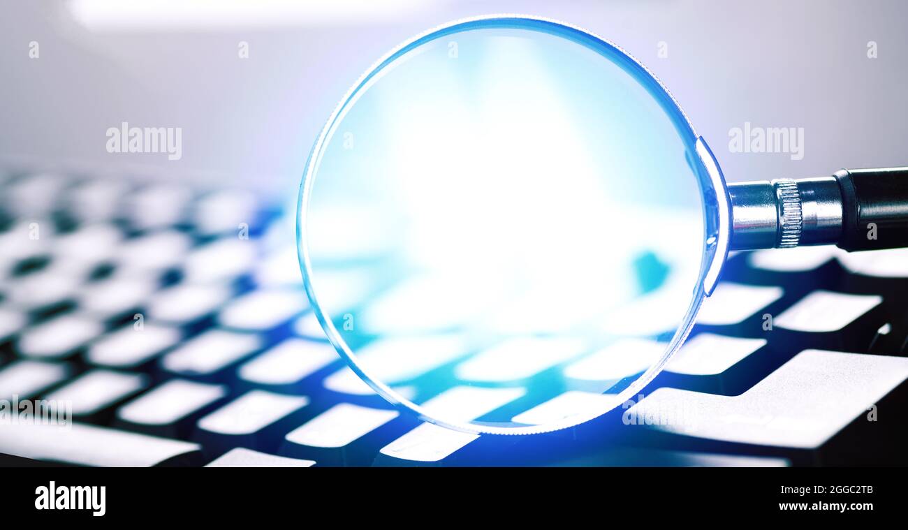 Magnifying glass on the keys of a black computer keyboard Stock Photo ...