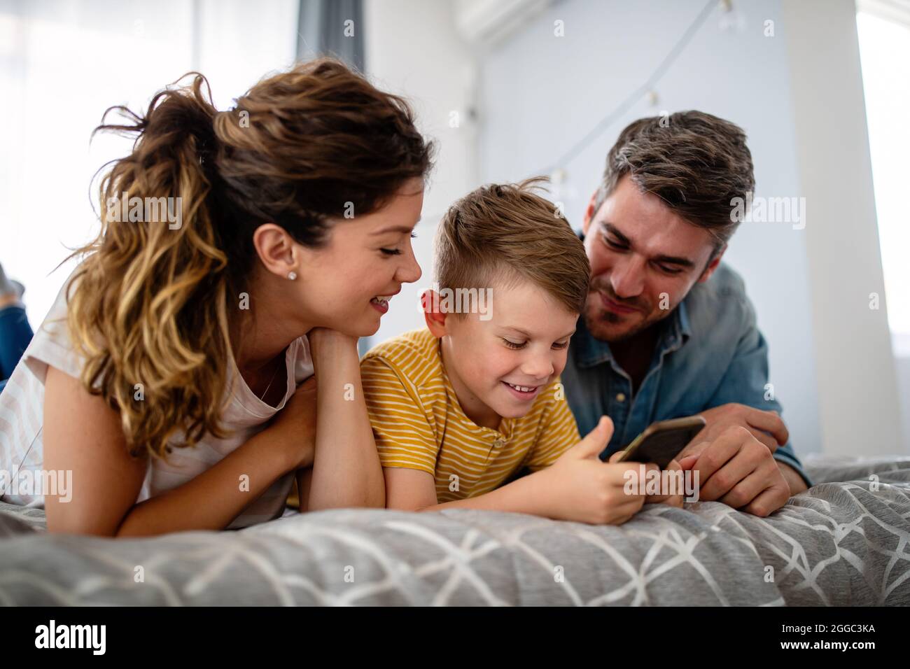 Happy family using technology devices together at home Stock Photo - Alamy