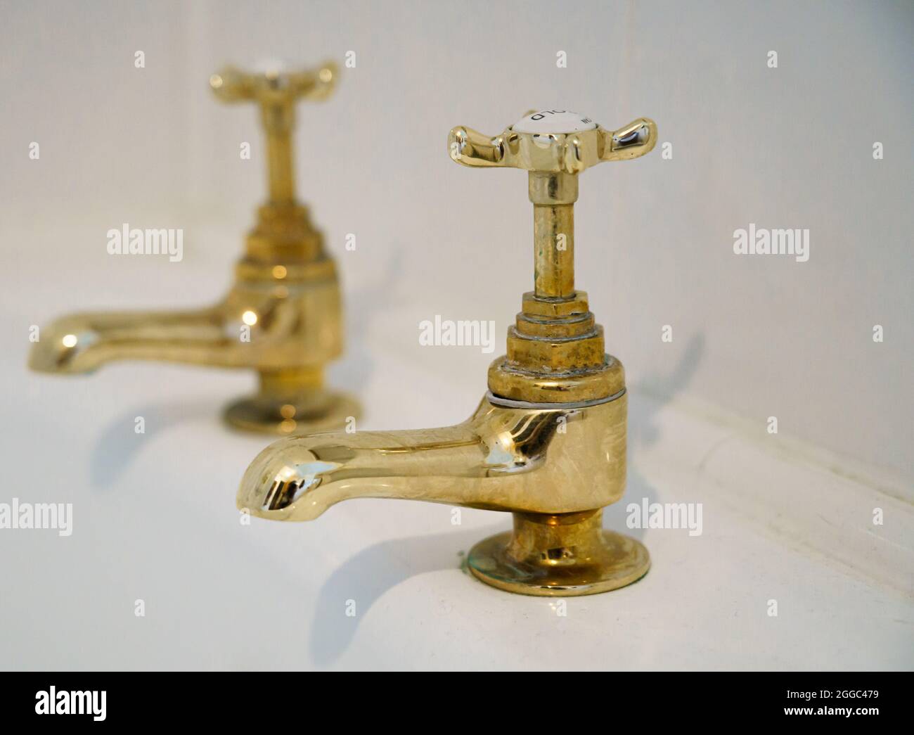 pair of vintage brass bath taps on a white enamel bath Stock Photo - Alamy
