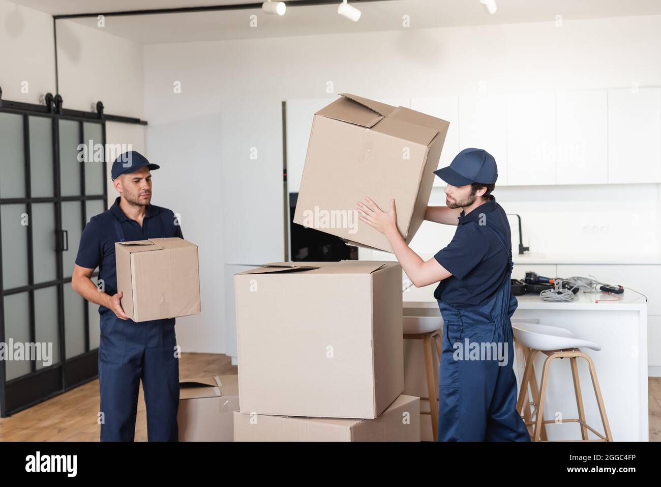 workers in uniform stacking carton packages in kitchen Stock Photo - Alamy