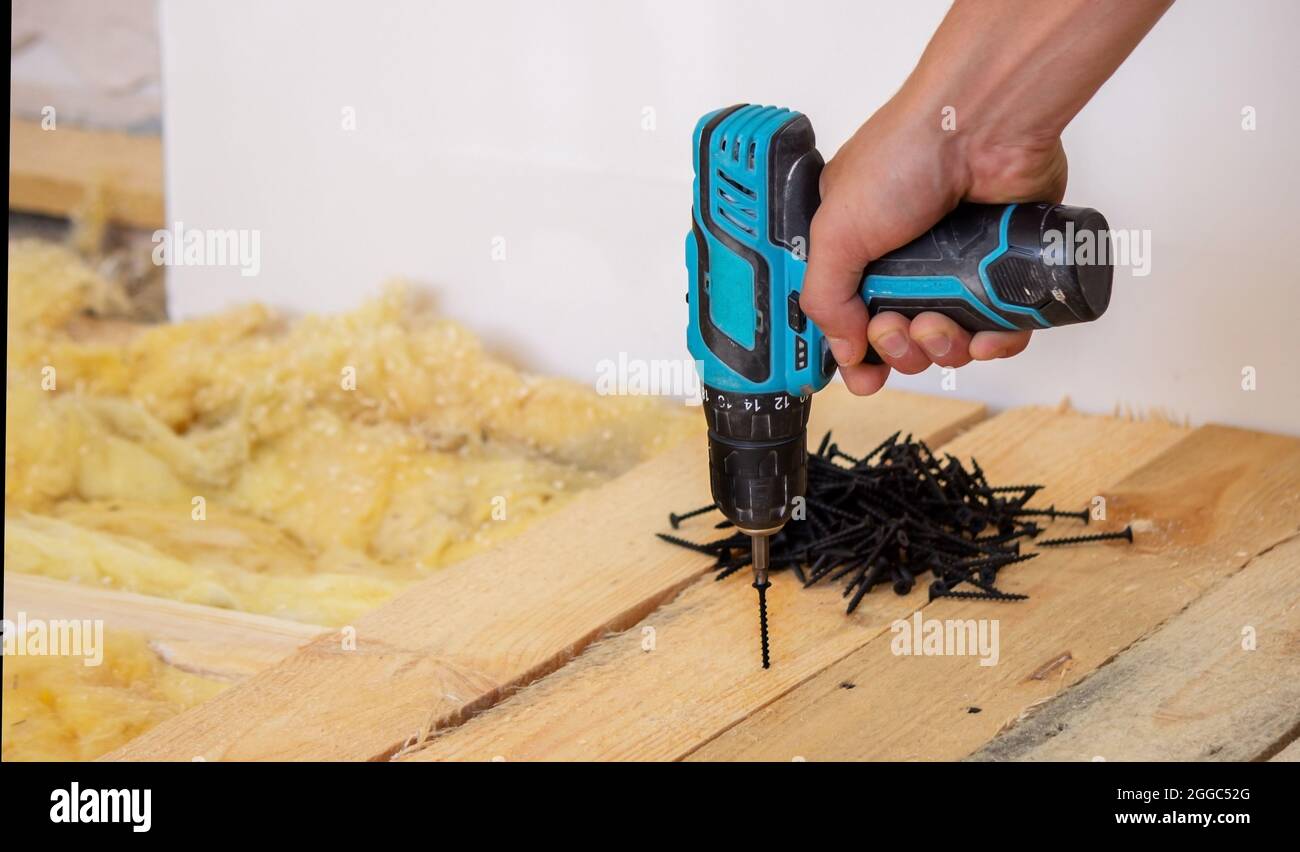 Hand with cordless screwdriver and drill isolated on white background ...