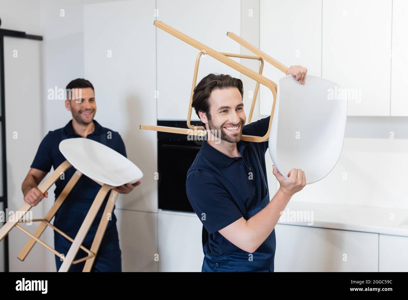 Men carrying chairs hi-res stock photography and images - Alamy