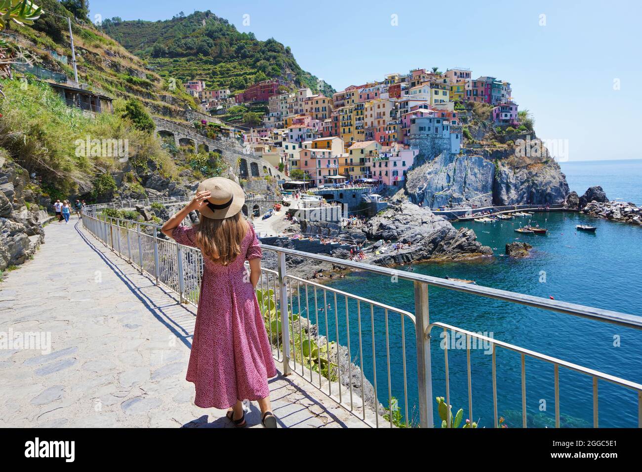 Young traveler woman with hat and dress descend along the promenade of ...