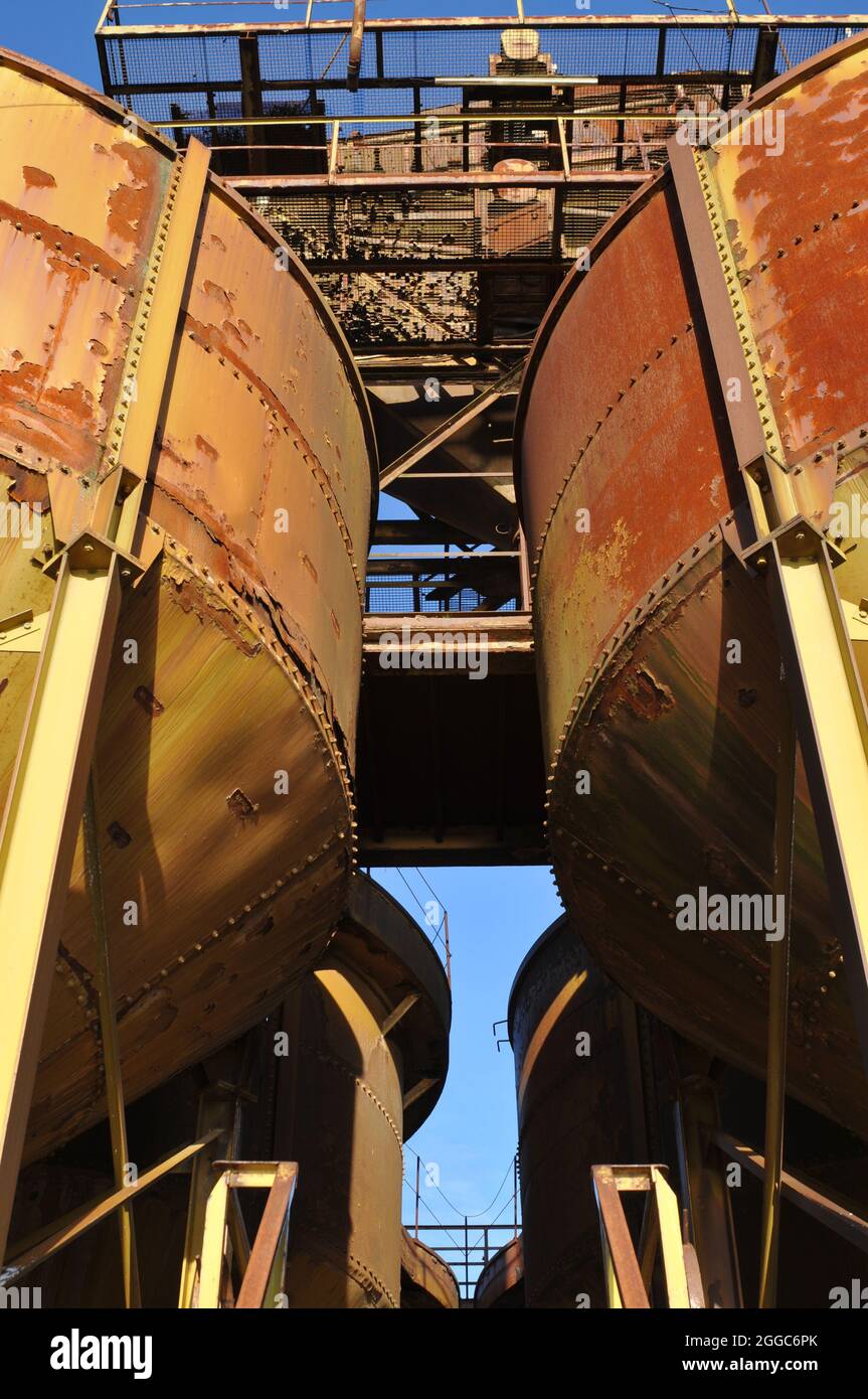 Vertical shot of old rusty silos in an industrial site Stock Photo - Alamy