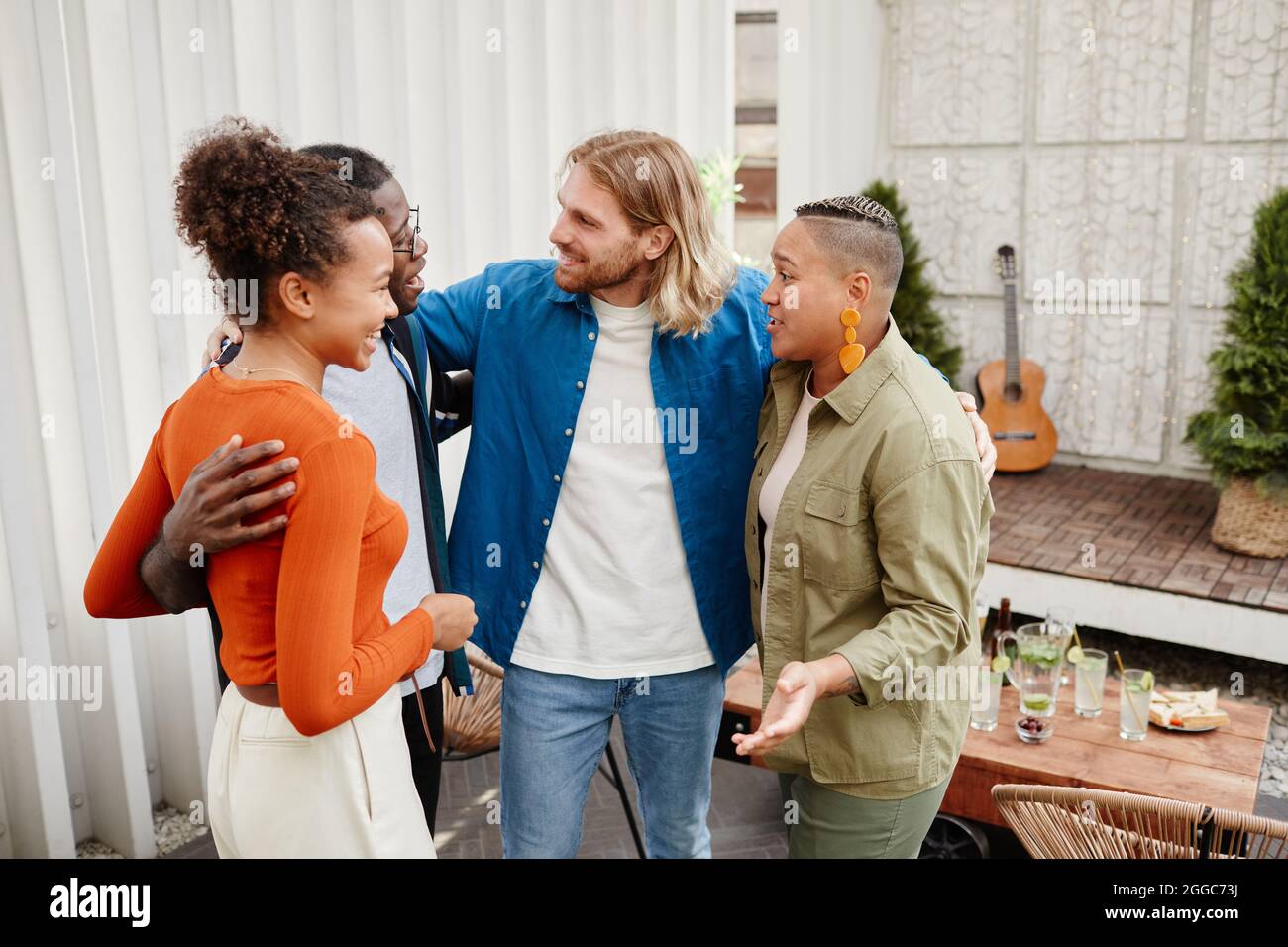 Diverse group of modern young people greeting each other at rooftop ...