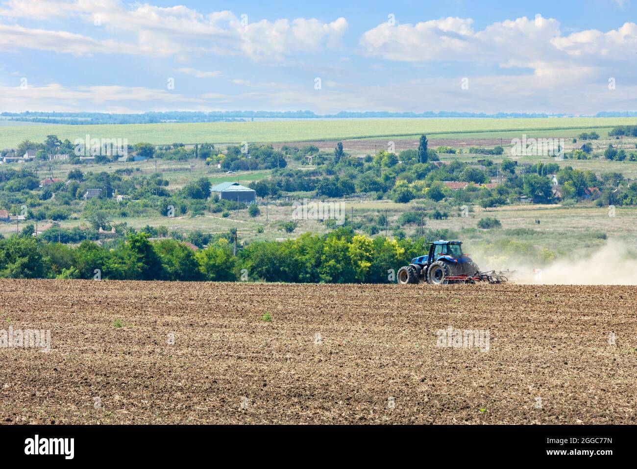 The tractor in the field shallow plow the soil with metal discs after ...