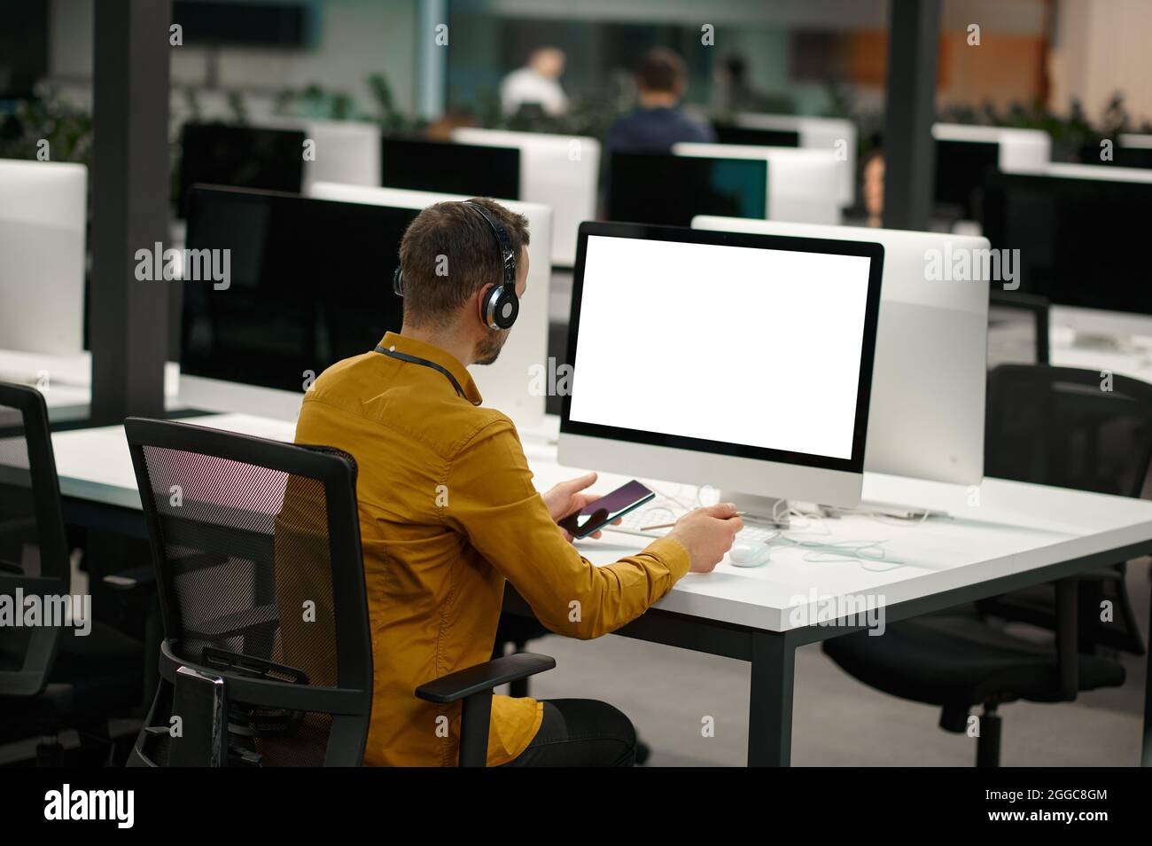Manager in headphones works on computer, IT office Stock Photo - Alamy
