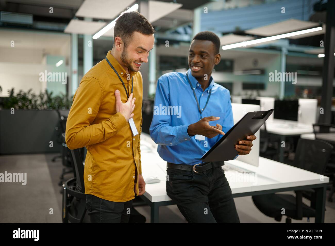 Two male employees, meeting in IT office Stock Photo - Alamy