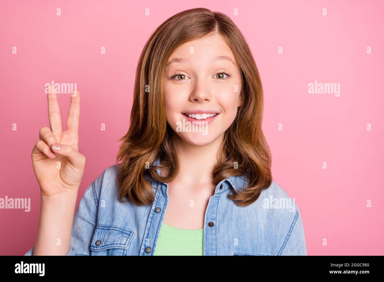 Photo portrait girl showing v-sign gesture smiling isolated pastel pink ...