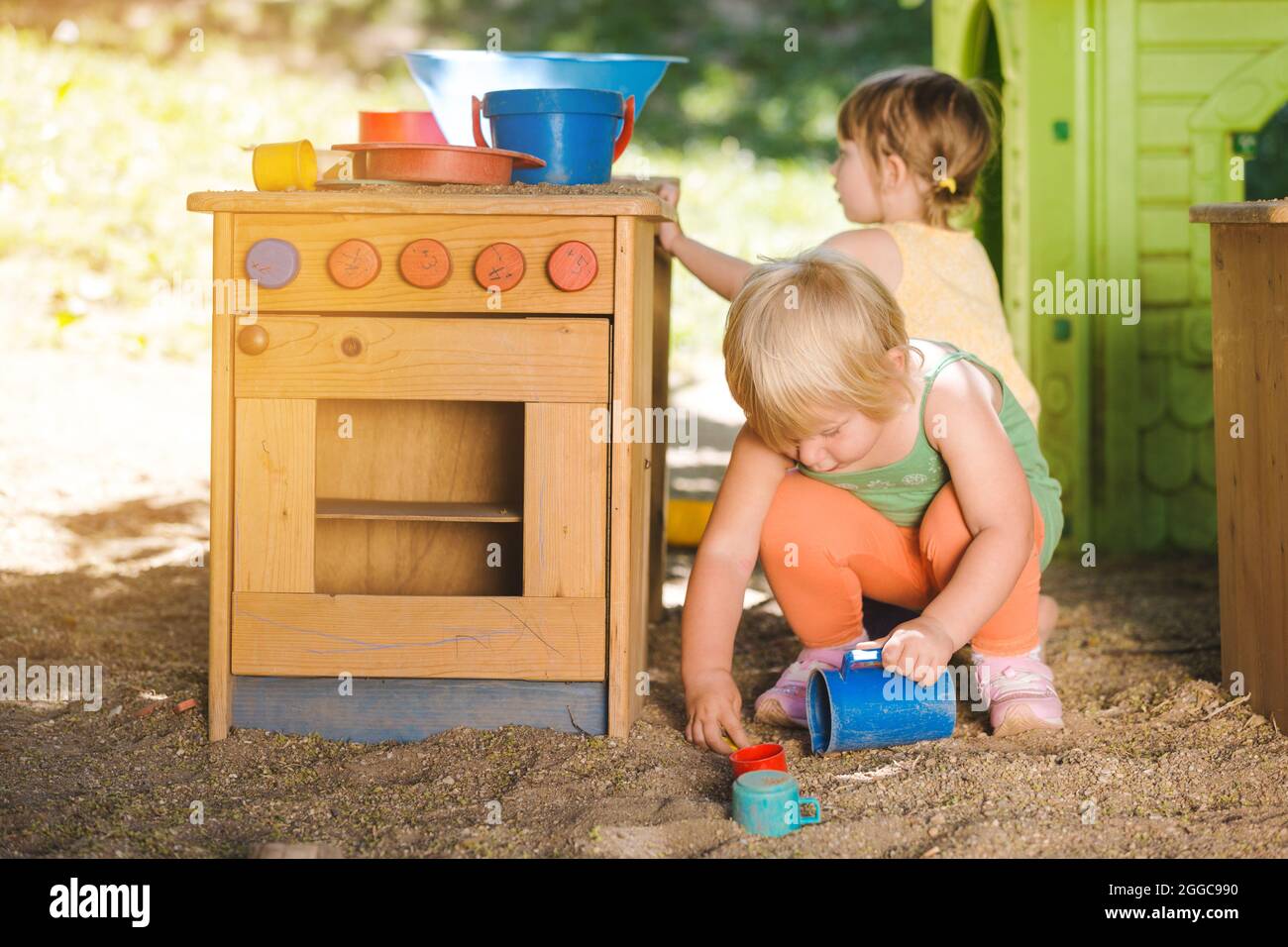 Little children playing outdoors in play kitchen Stock Photo - Alamy