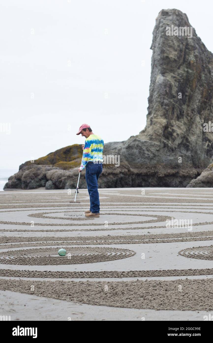 A volunteer for Circles in the Sand, working on a sand labyrinth in ...