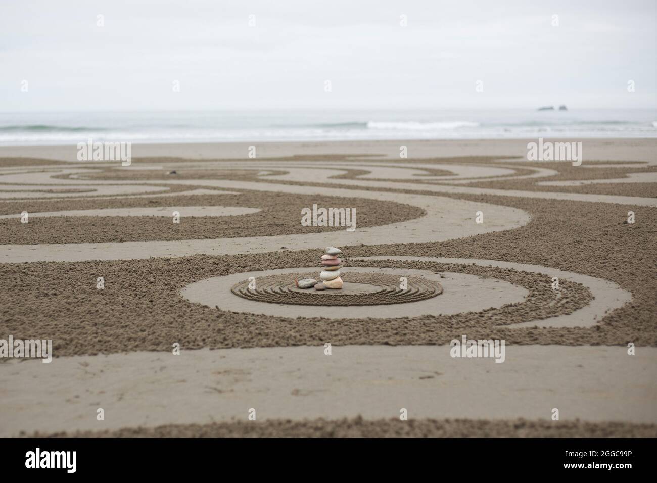 A stack of rocks is part of a sand labyrinth in Bandon, Oregon, USA ...