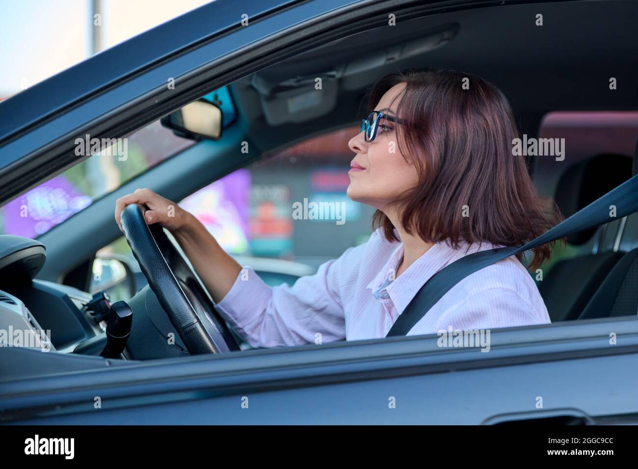 Middle-aged beautiful woman driver driving a car Stock Photo - Alamy