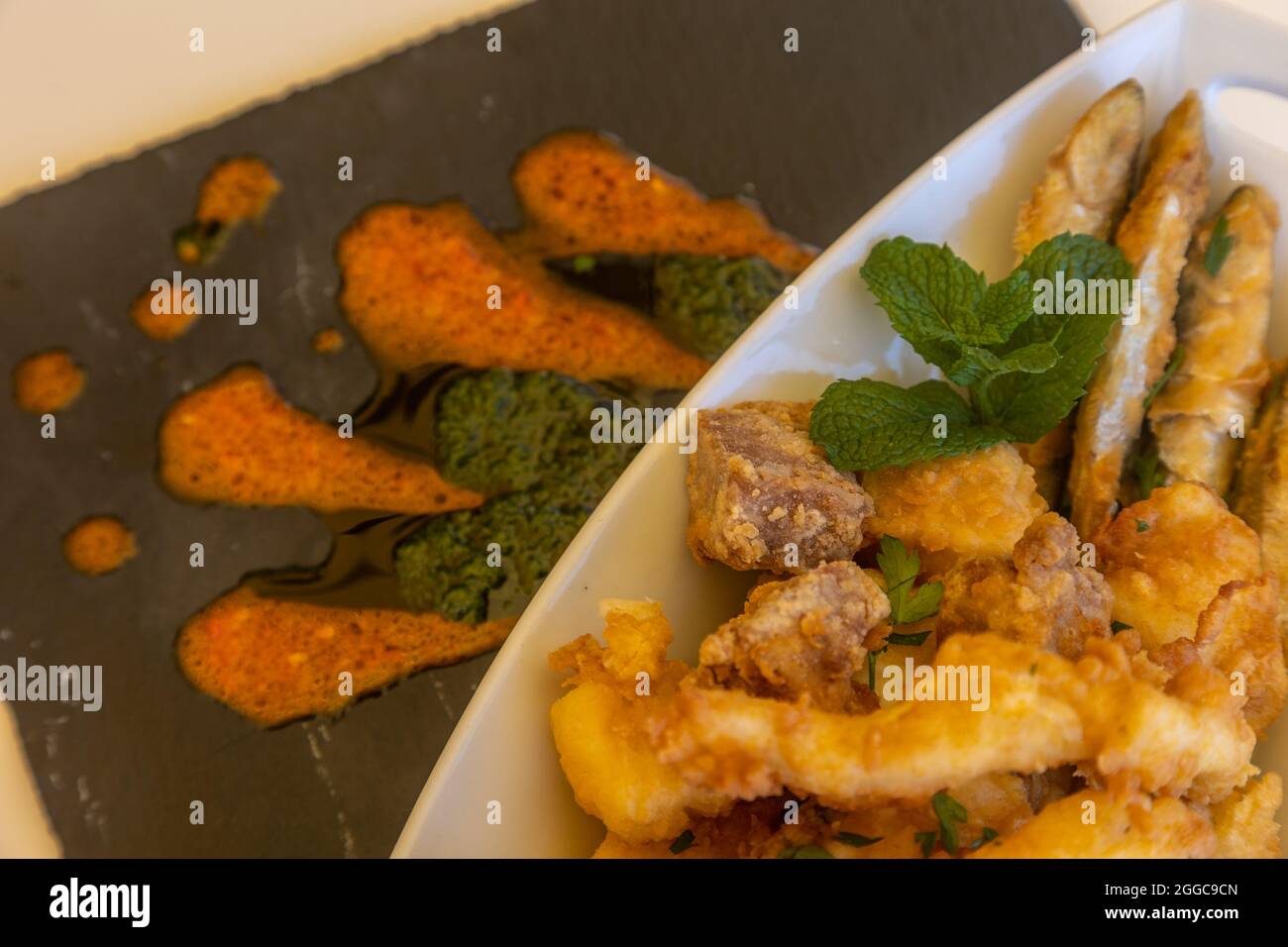 Closeup shot of fried shrimps and fish decorated with lemon and mint on ...