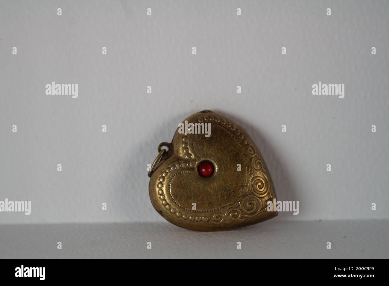 Closeup shot of an old heart shape metal button on an isolated ...