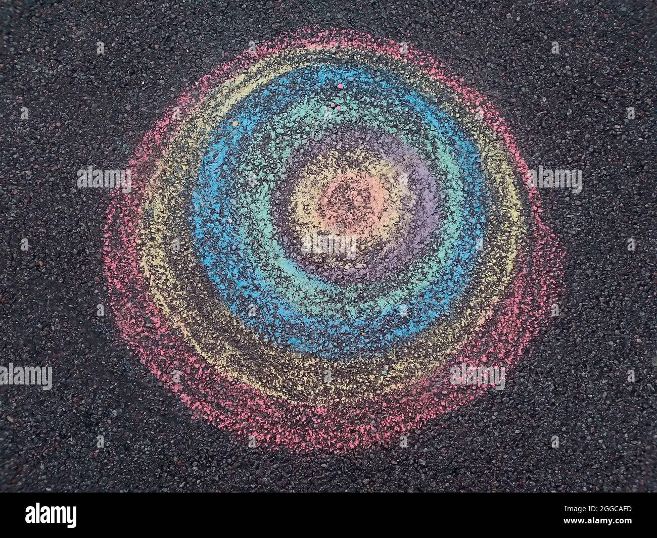 Child asphalt chalk drawing of colorful rounds on old grunge asphalt ...
