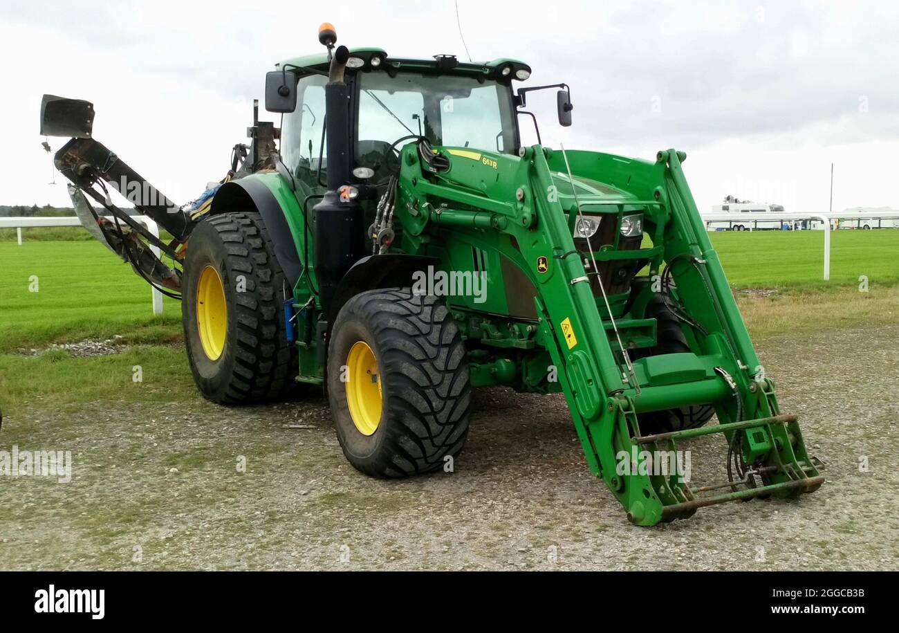 A green John Deere 6 series tractor with a 663R front loader parked in ...