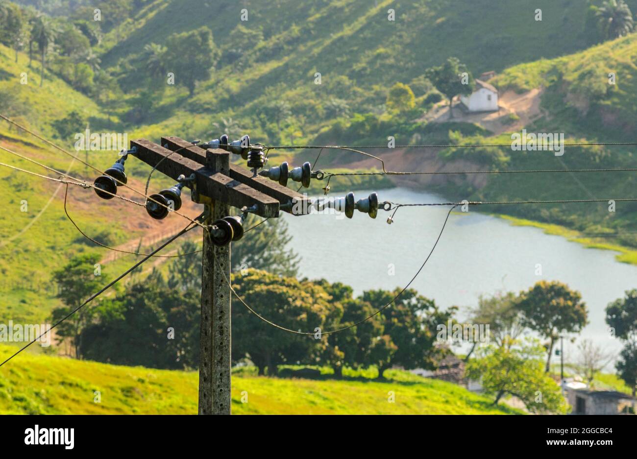 Rural electrification pole in the countryside with lake and mountains ...