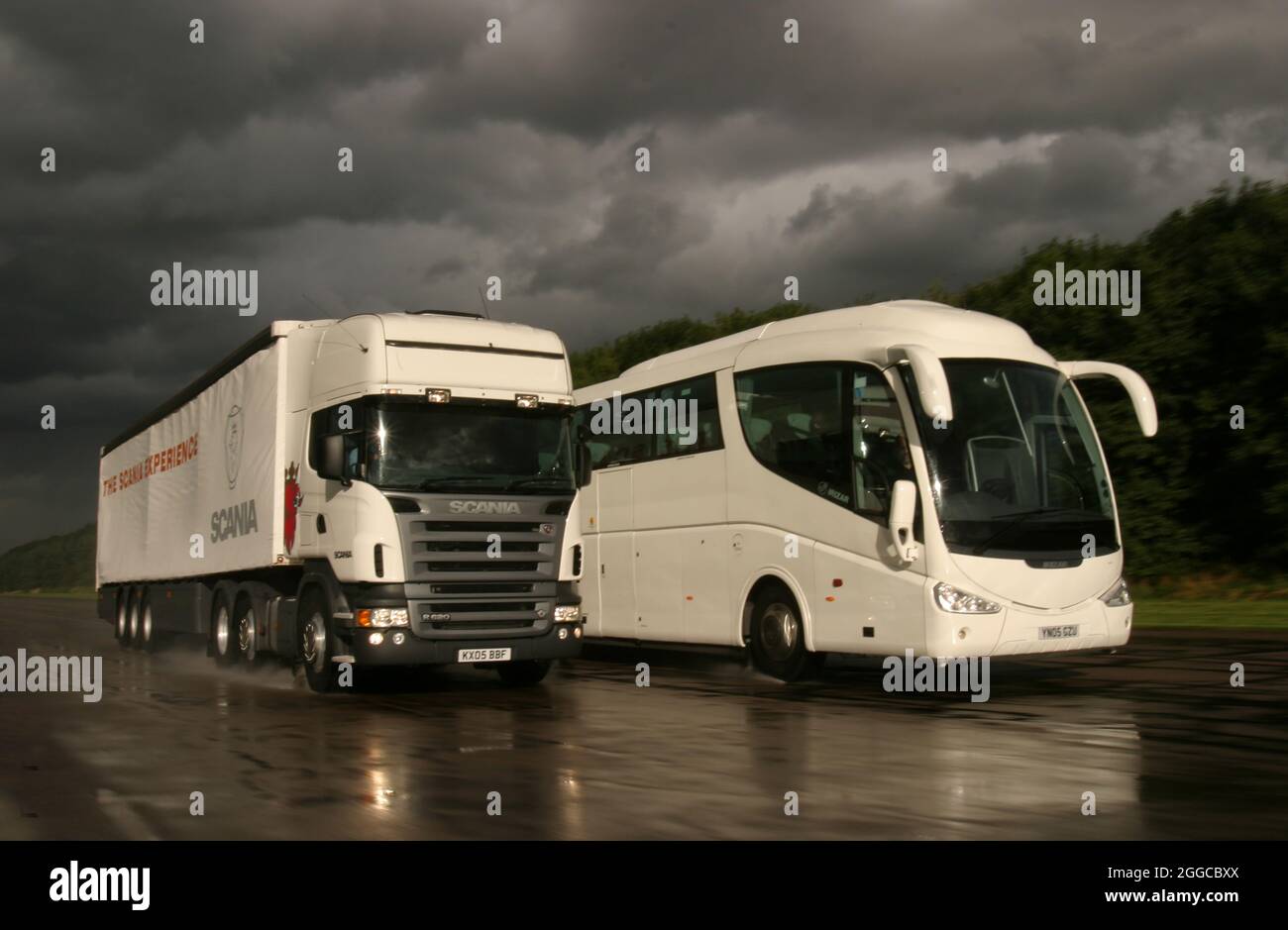HGV truck passing a coach on a wet test track Stock Photo - Alamy