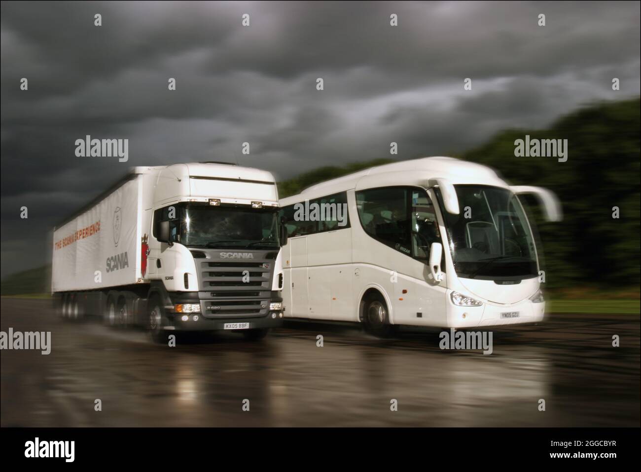HGV truck passing a coach on a wet test track Stock Photo - Alamy