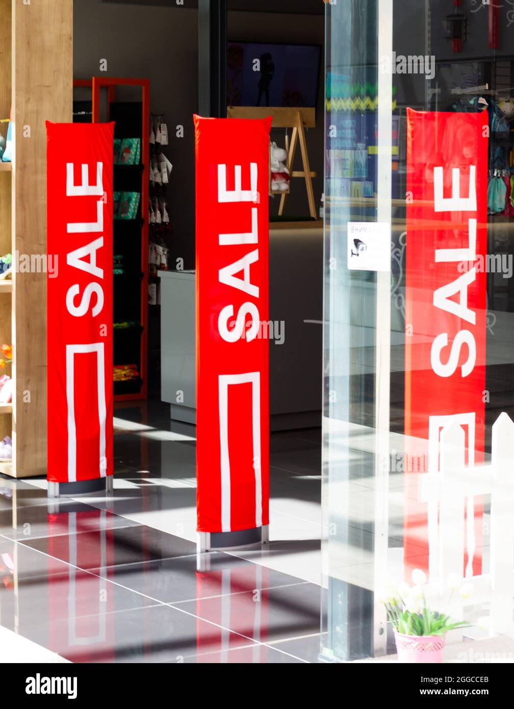 Showcases of a clothing store with red stands with sale signs. Time of ...