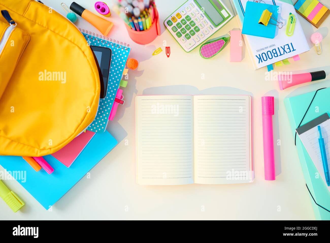 Back to school. Upper view of white desk with blank notebook, workbooks ...