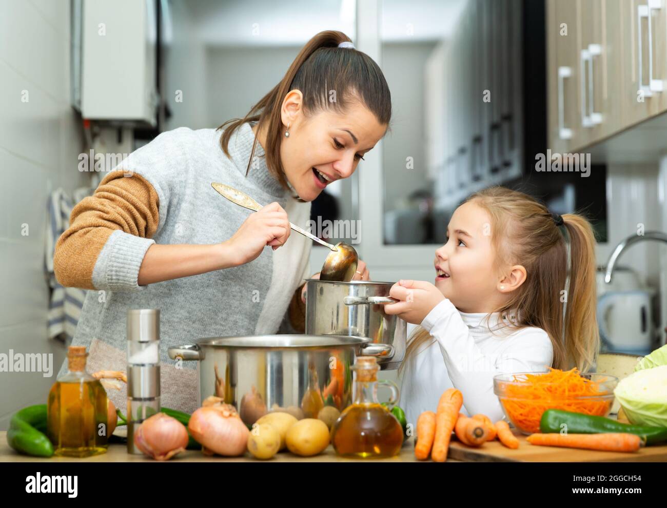 Small girl helping mother soup hi-res stock photography and images - Alamy